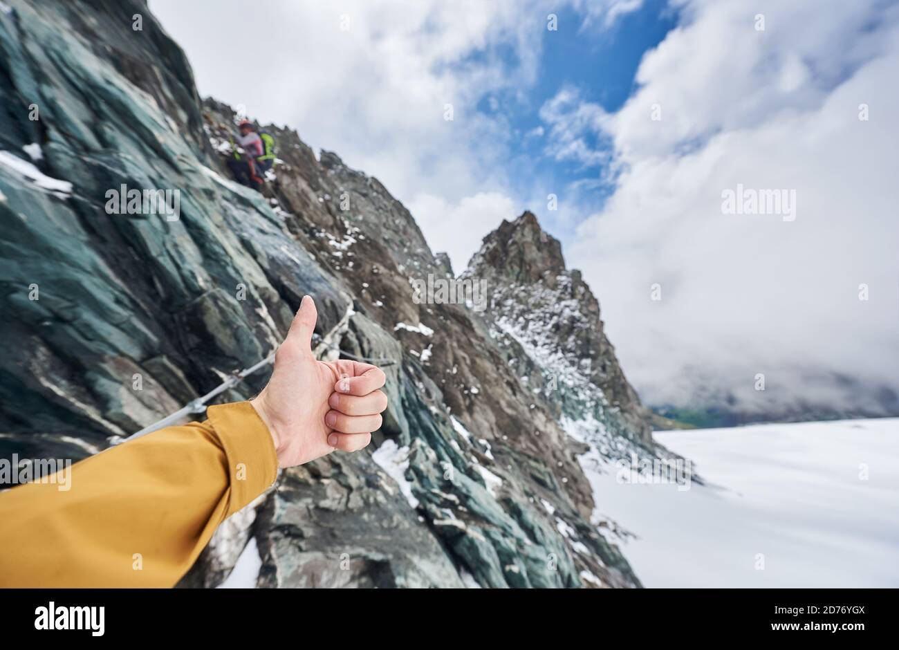 Close up of alpinist hand doing approval gesture with rocky mountains ...