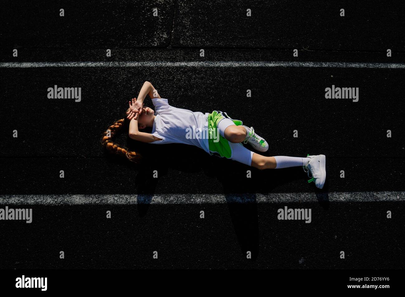 Girl jogging on a sunny summer evening, laying on treadmill, stadium ...