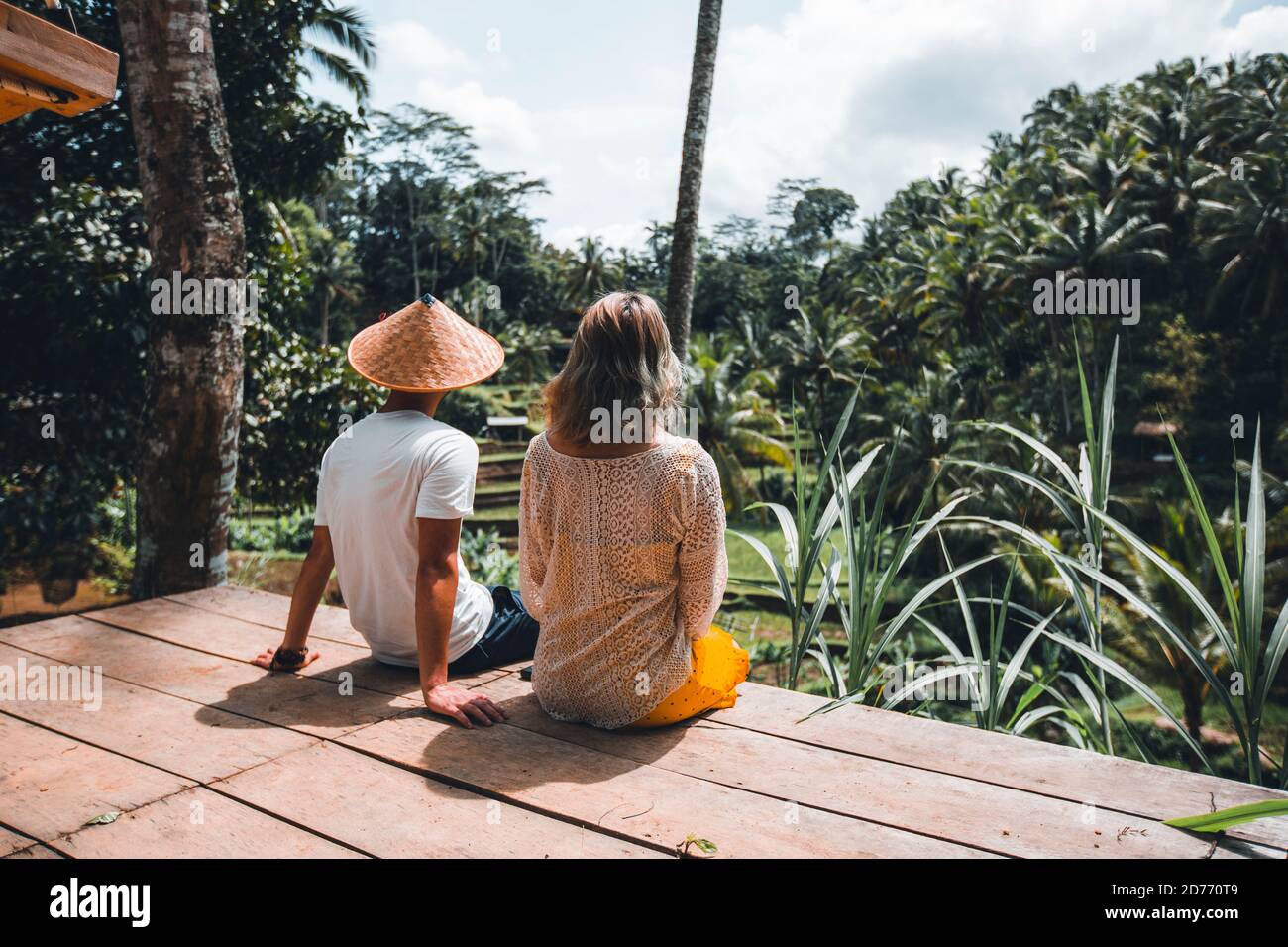 Holiday photograph couple seating on wooden panel looking over the rice ...