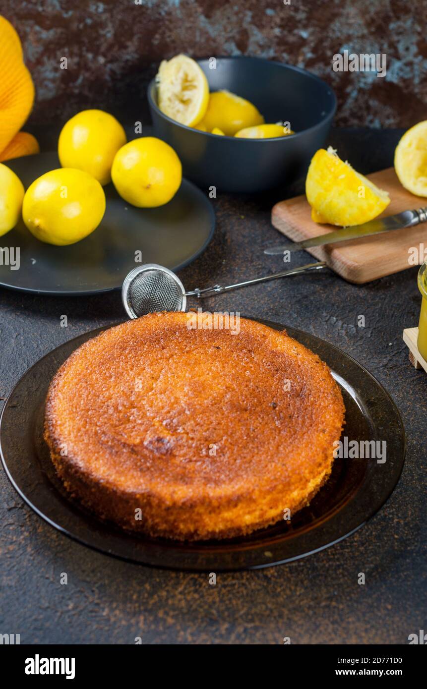 freshly baked sponge cake on plate, lemon curd and lemons Stock Photo ...