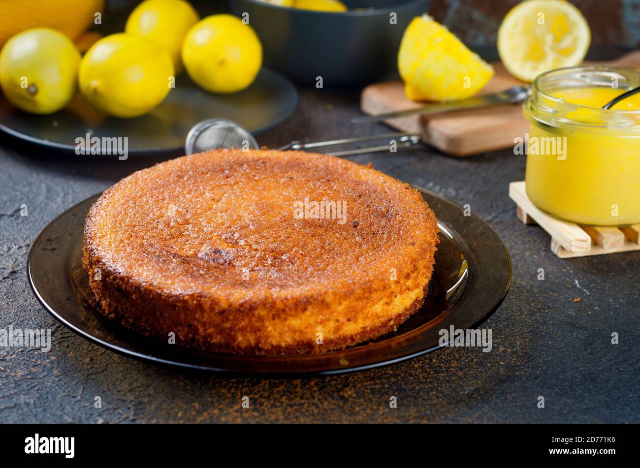 freshly baked sponge cake on plate, lemon curd and lemons Stock Photo ...
