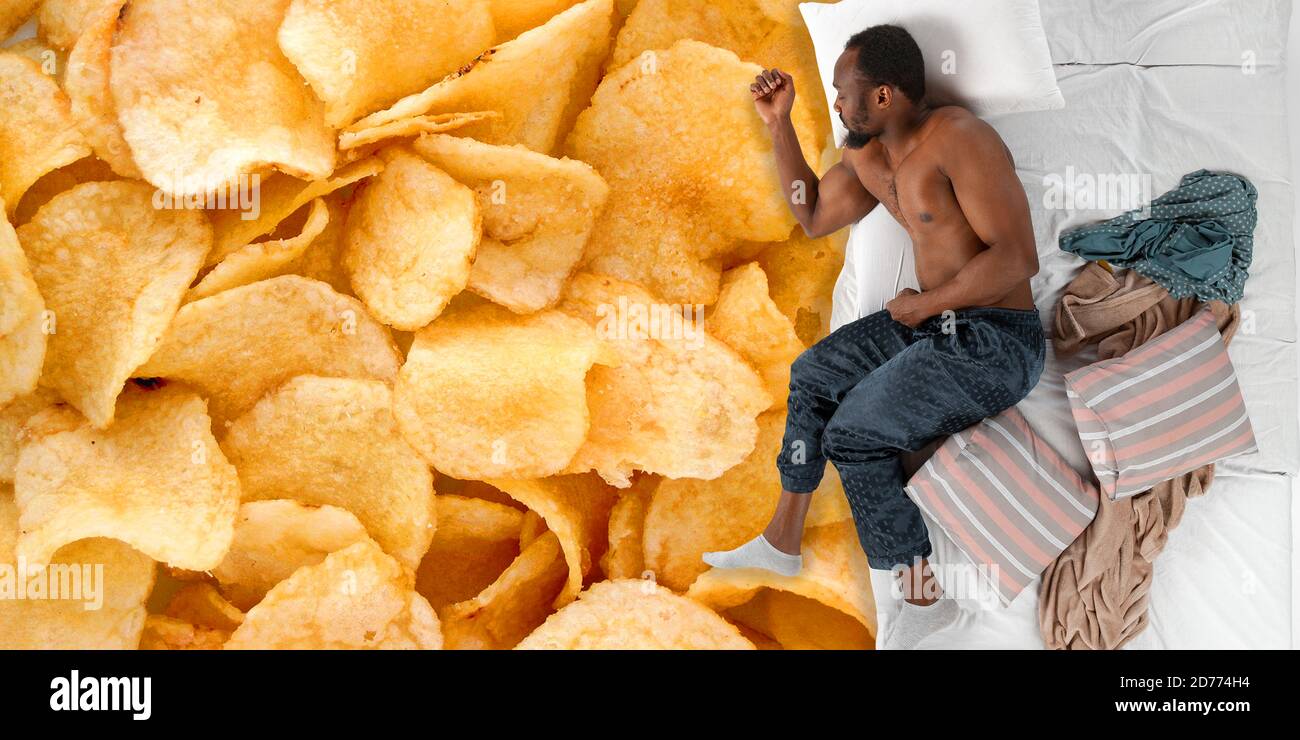 Feels hunger. Portrait of a young man sleeping in comfortable bed and ...