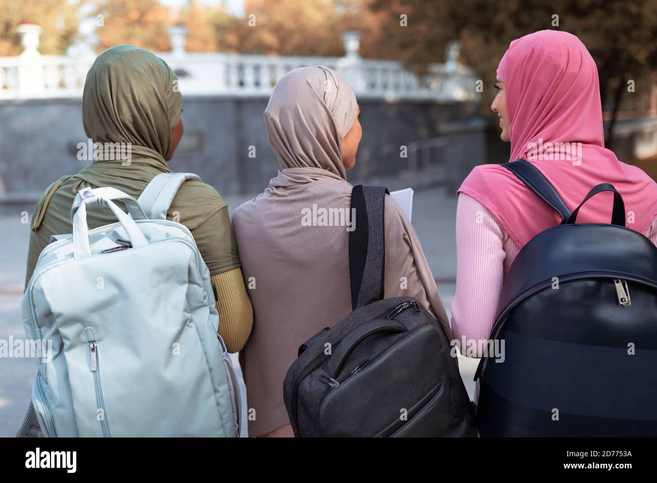 Three Muslim Ladies With Backpacks Walking Back To Camera Outdoor Stock ...
