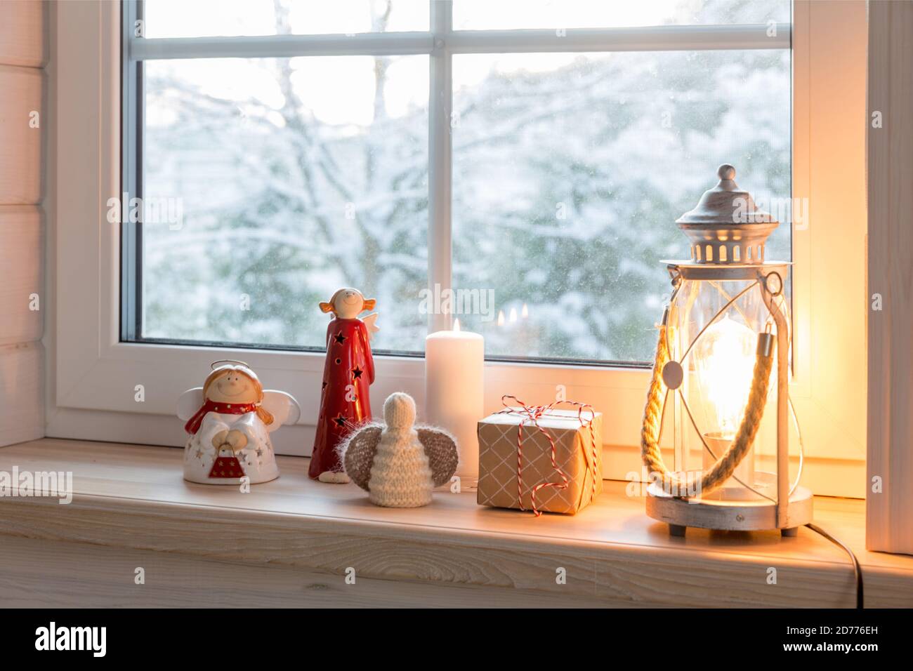 Christmas lantern, angels with gifts on the window of a wooden house ...