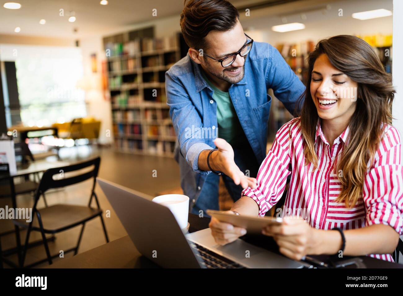 Happy young people working together on laptop. Teamwork, study ...