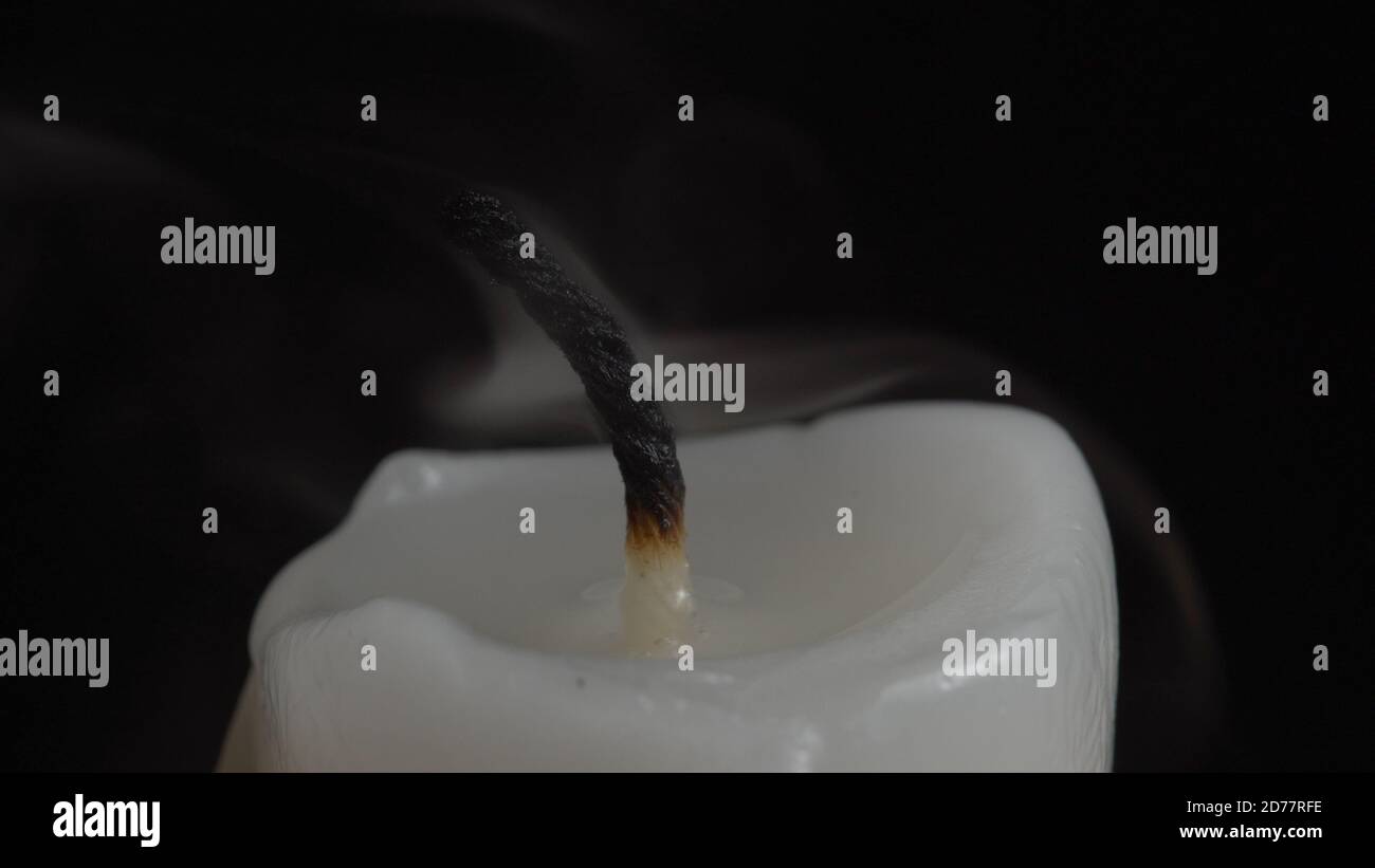 Image of smouldering white candle on black background Stock Photo - Alamy