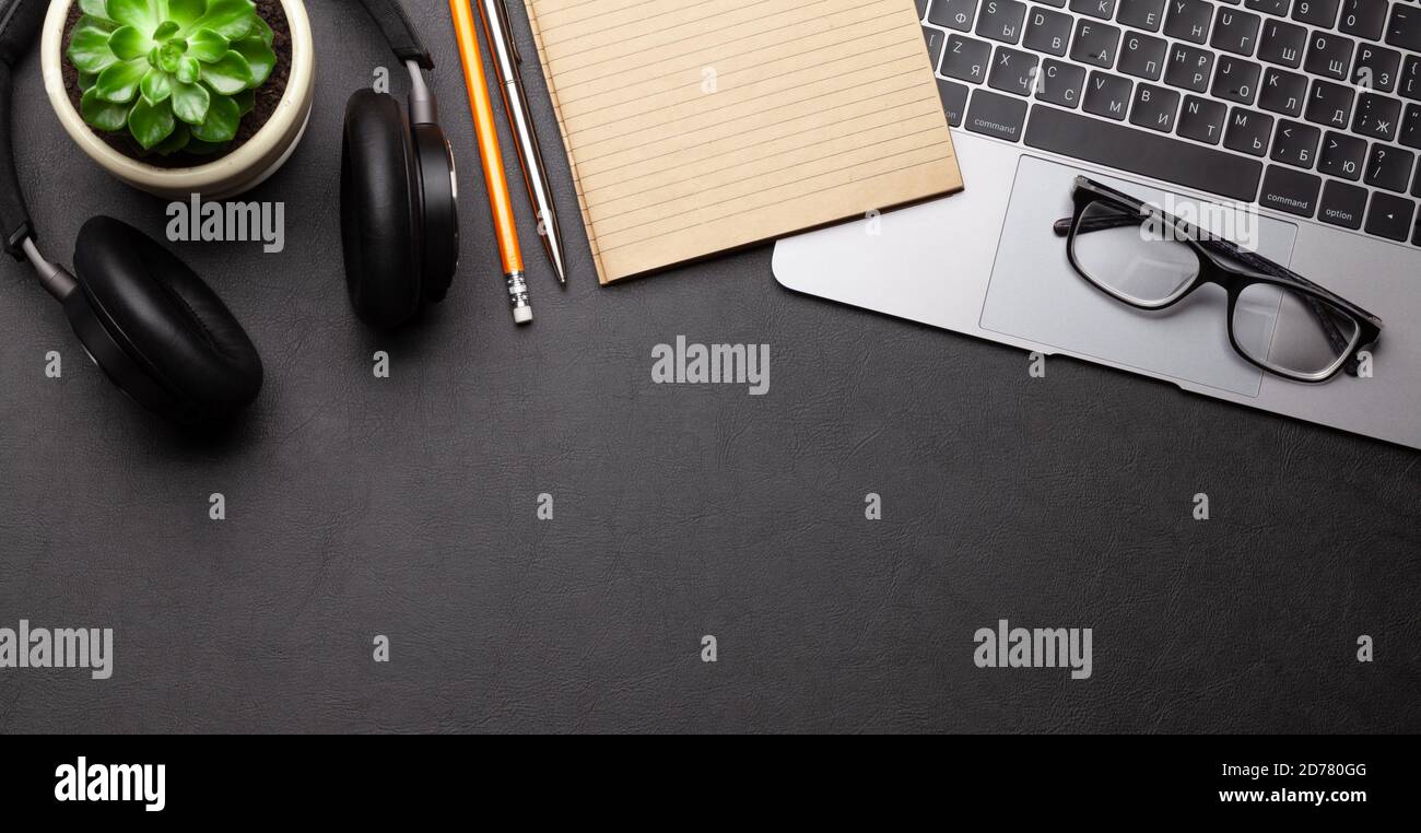 Business desk workplace and office objects over black leather backdrop ...