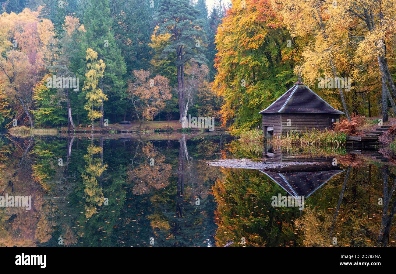 Autumn colours on woodland foliage and wooden boathouse at Loch Dunmore ...