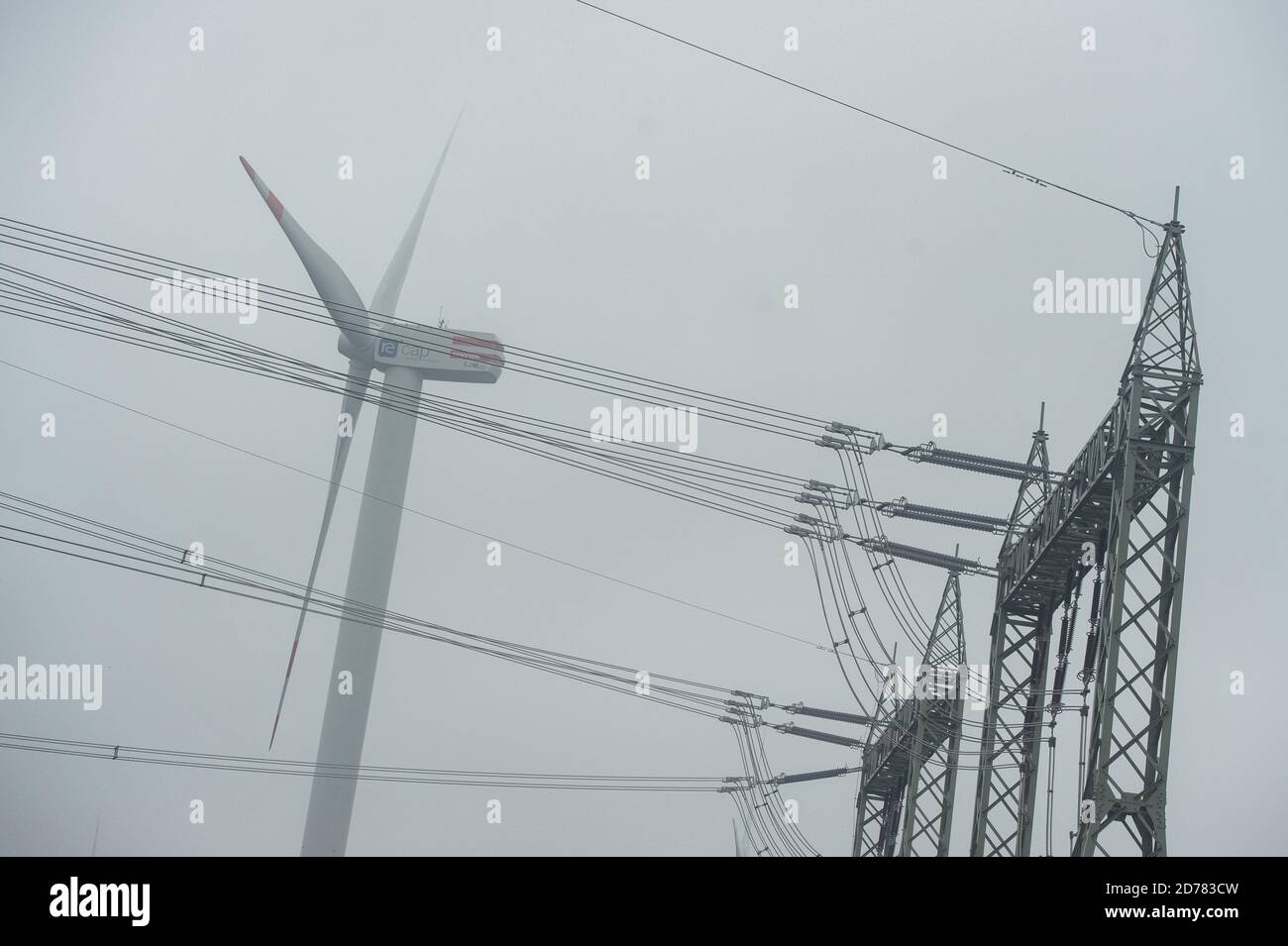 Handewitt, Germany. 21st Oct, 2020. A line gantry and a wind turbine ...
