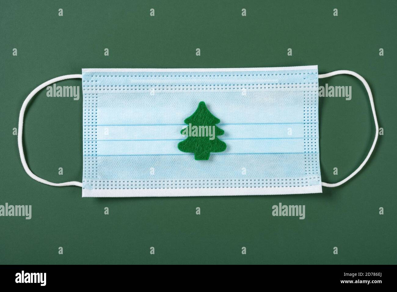 medical mask with a Christmas tree on top over green background Stock ...