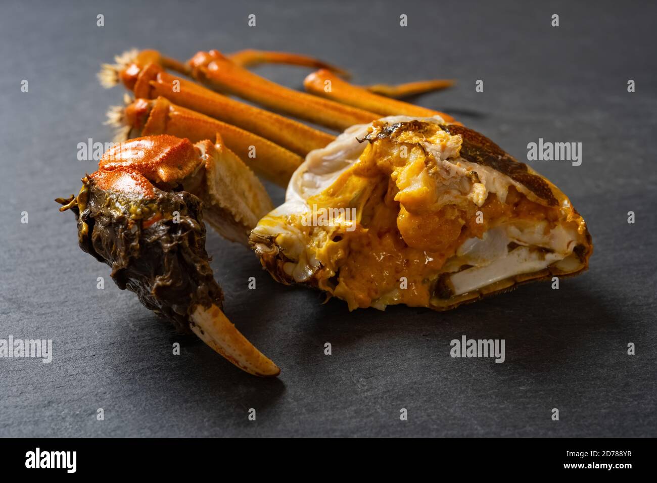 half of a cooked crab with lots of crab roe on a dark background Stock ...