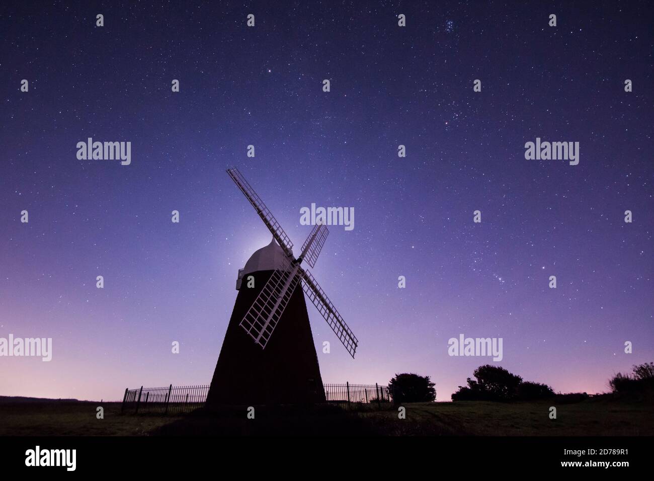 Halnaker windmill silhouetted by moonlight behind roof, at night with ...