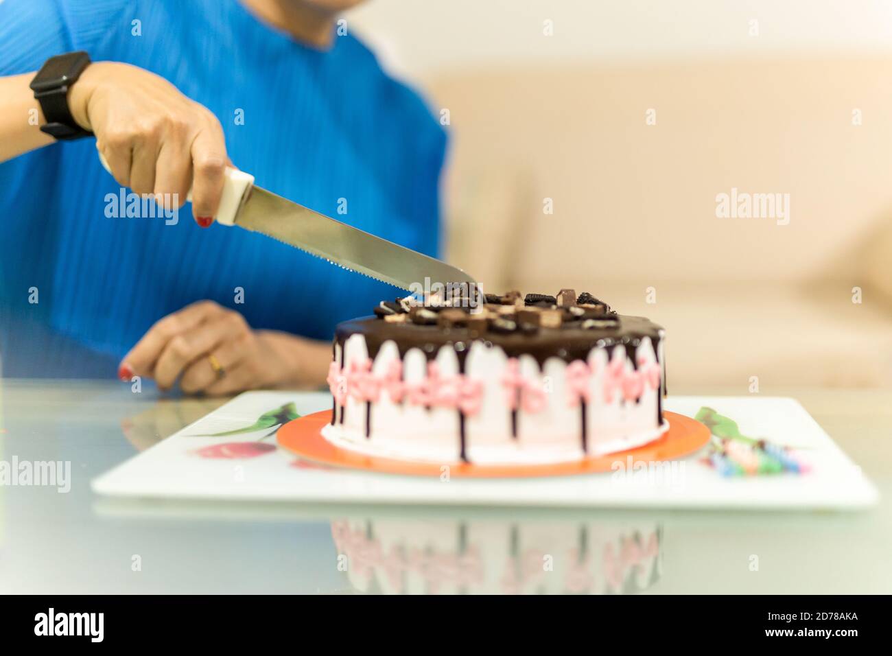 Woman is hand cutting birthday cake in blur backgroung Stock Photo - Alamy