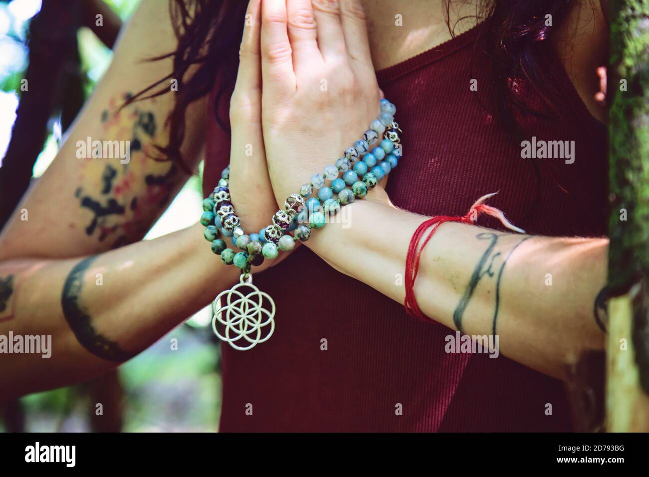 Female hands doing namaste mudra yoga practice in forest with mala ...