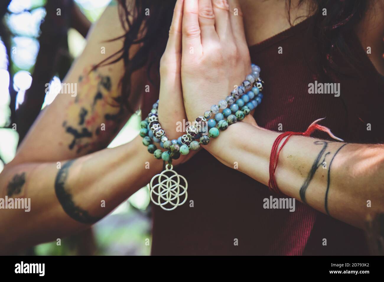 Female hands doing namaste mudra yoga practice in forest with mala ...