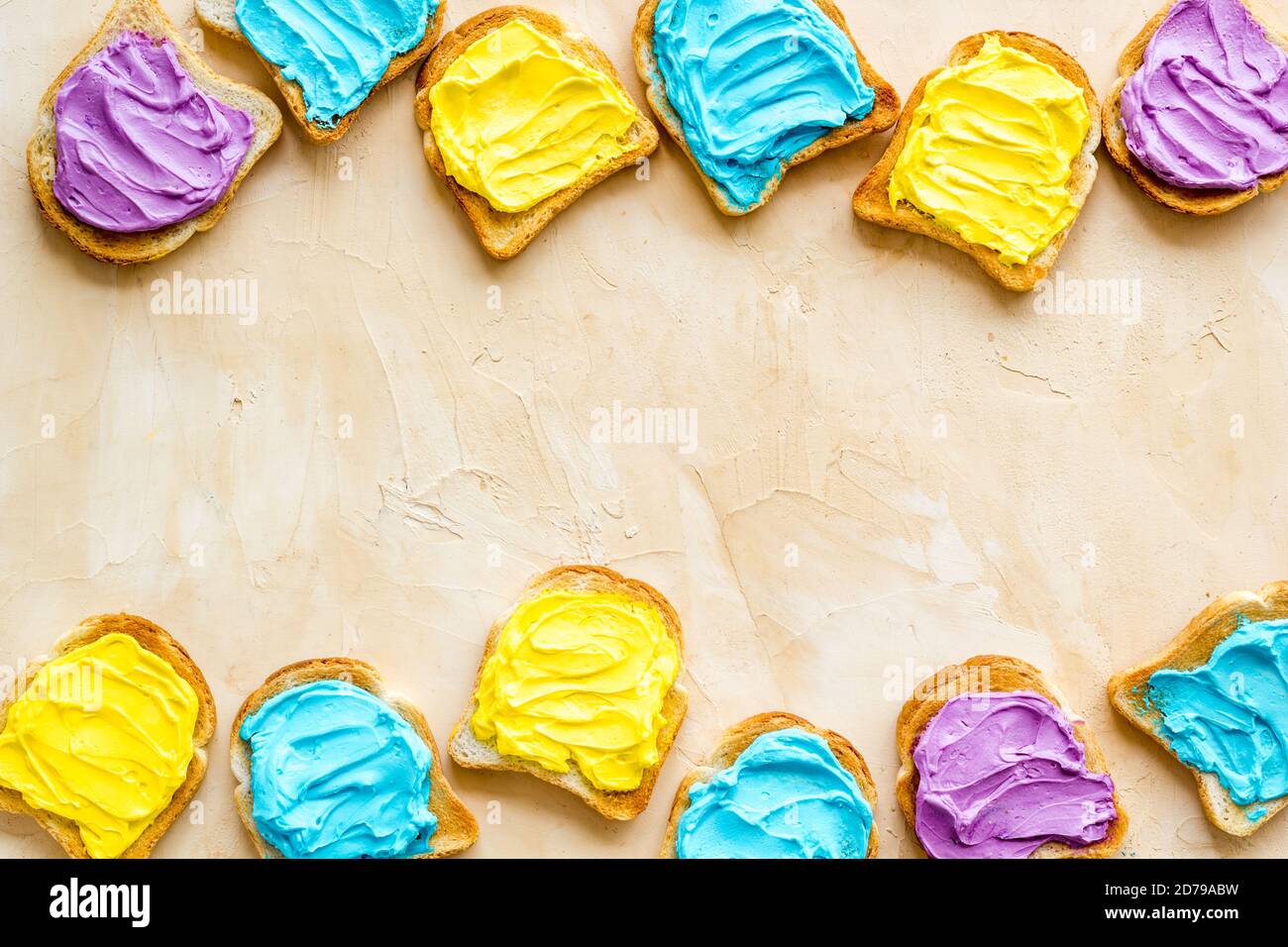 Funny toasted bread with colored cheese spread. Overhead view Stock ...