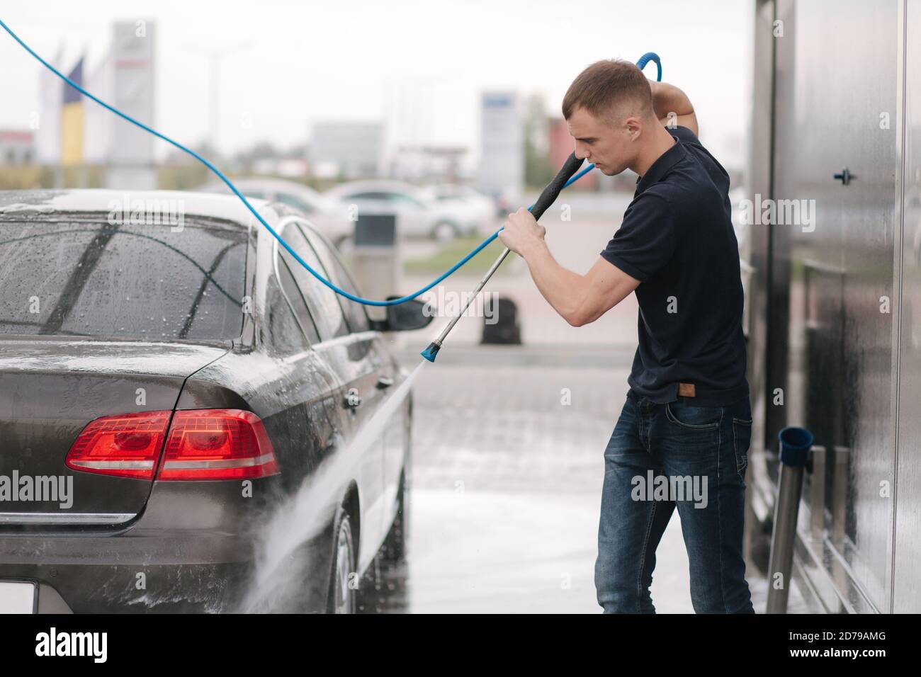 Car washing. Cleaning car using high pressure wax for shinig. Man ...