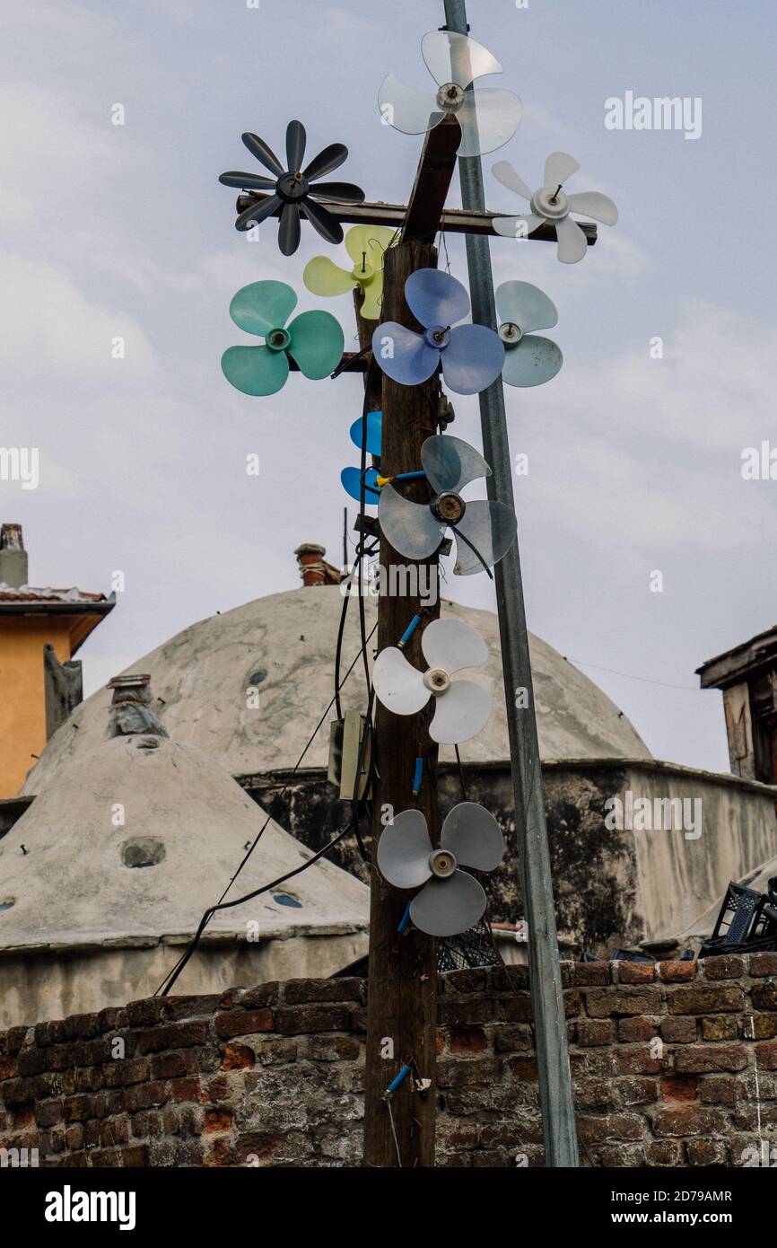Vertical shot of plastic pinwheels on a wooden pole under the blue sky ...
