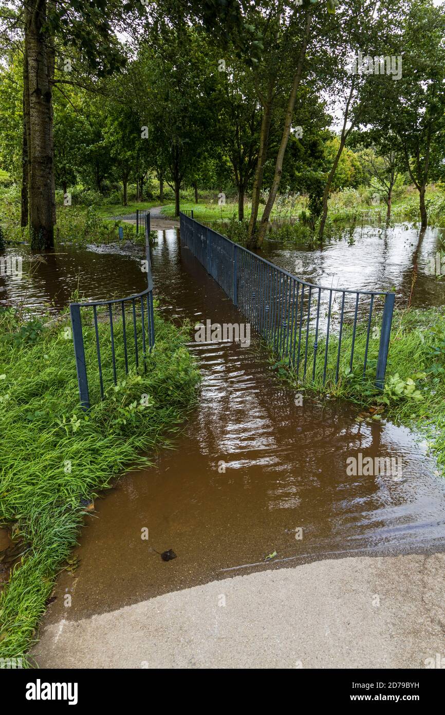 Blackwater river flooding over a footbridge in the park, grounds at the ...