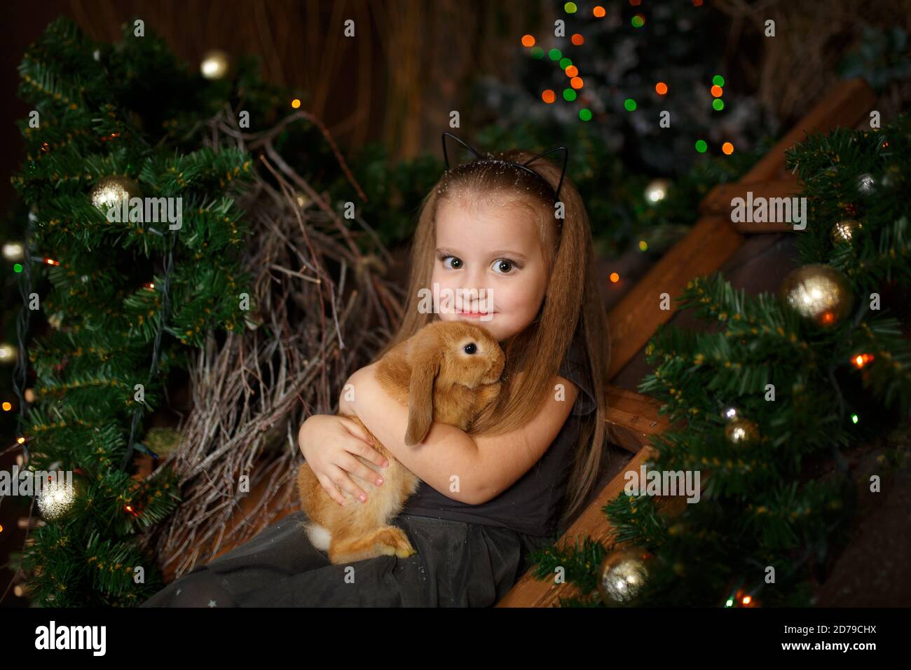 The little princess got a rabbit for Christmas. Christmas magic fairy ...