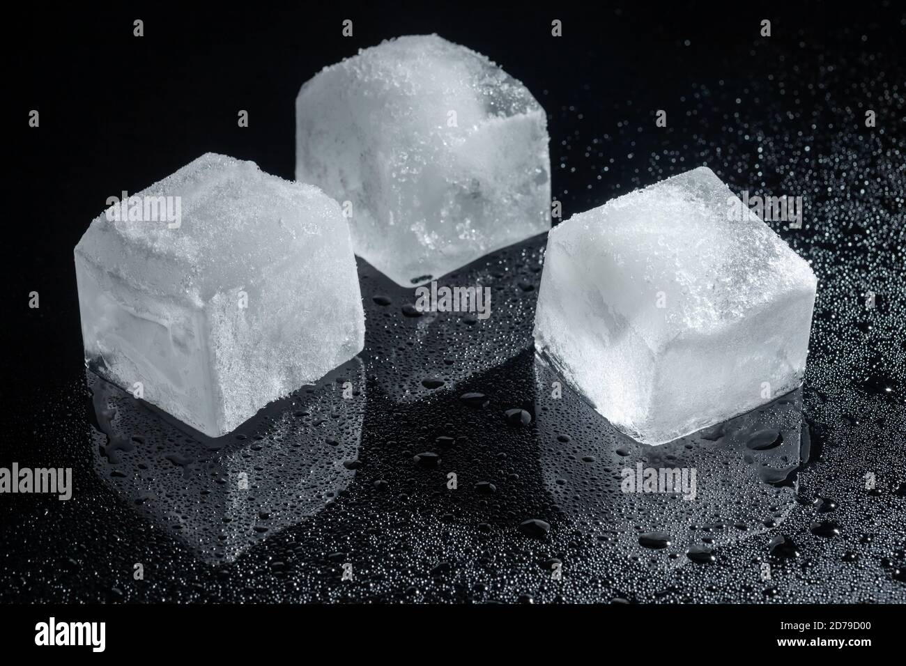 three ice cubes on black glass Stock Photo - Alamy