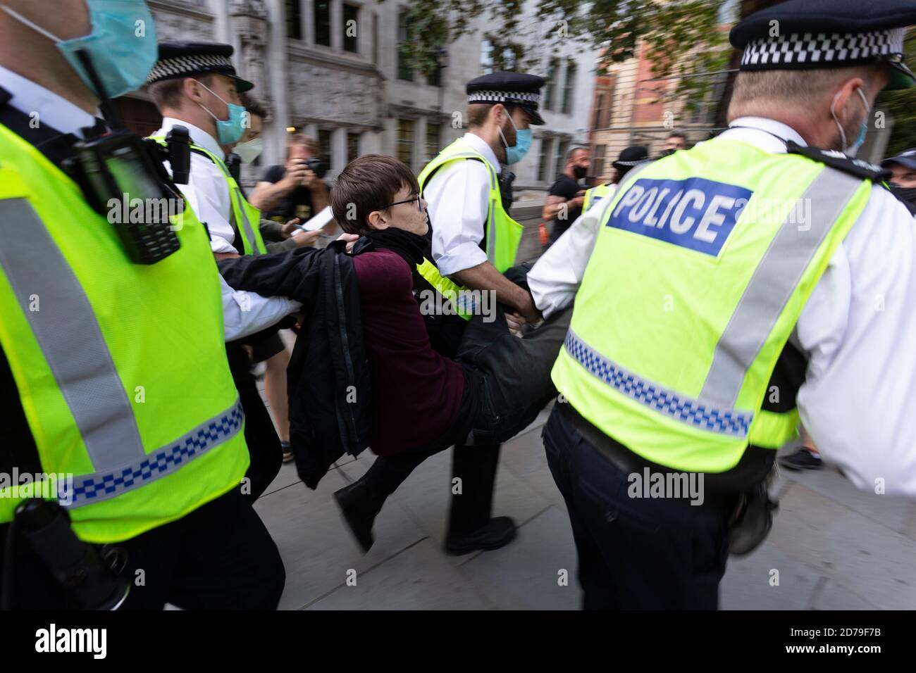 Police carry off an arrested protester during an Extinction Rebellion ...