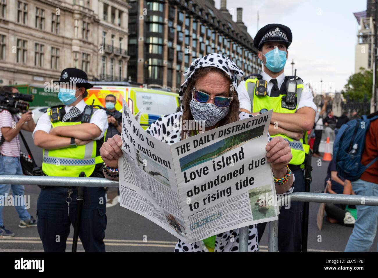 Protester reading a satirical newspaper during an Extinction Rebellion ...