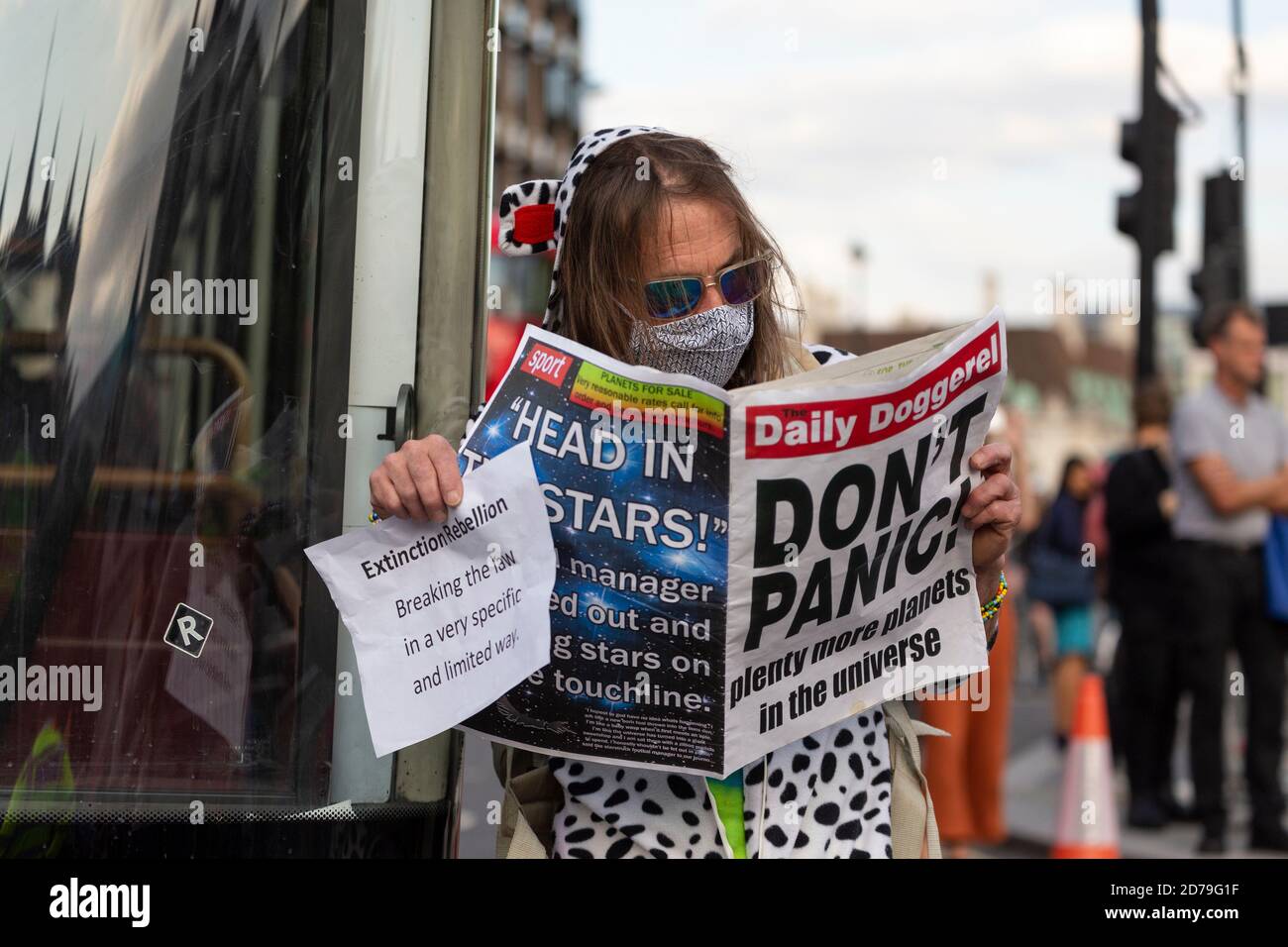 Protester reading a satirical newspaper during an Extinction Rebellion ...