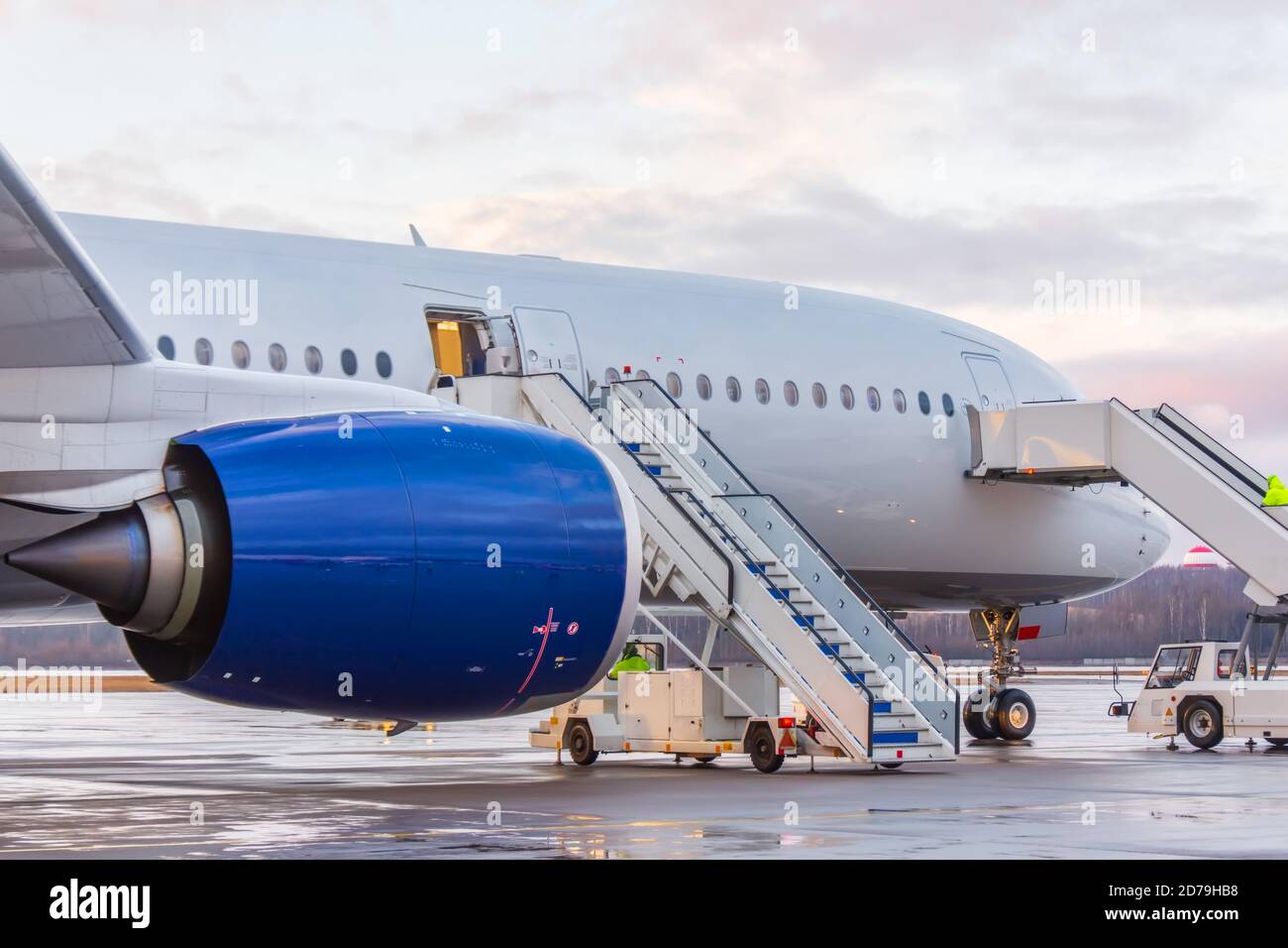 Wide body aircraft blue engine with ladder stairs to the airport ...