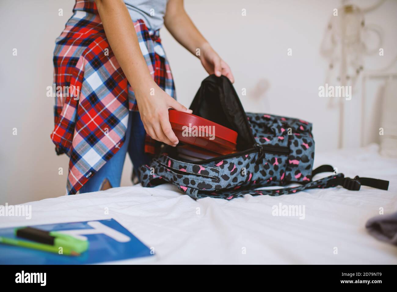 School girl putting school supplies into backpack Stock Photo - Alamy