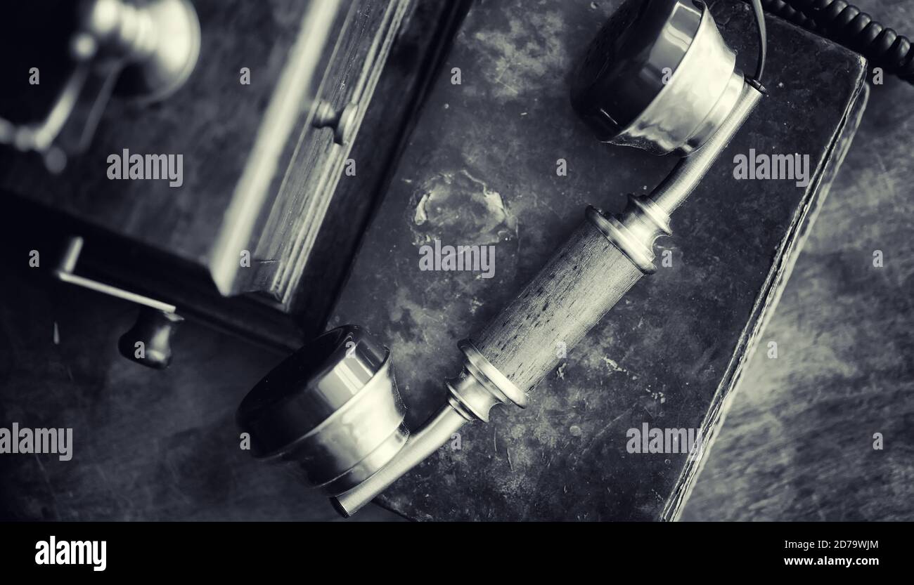 Old telephone and retro book on the desk. The phone of the past on an ...
