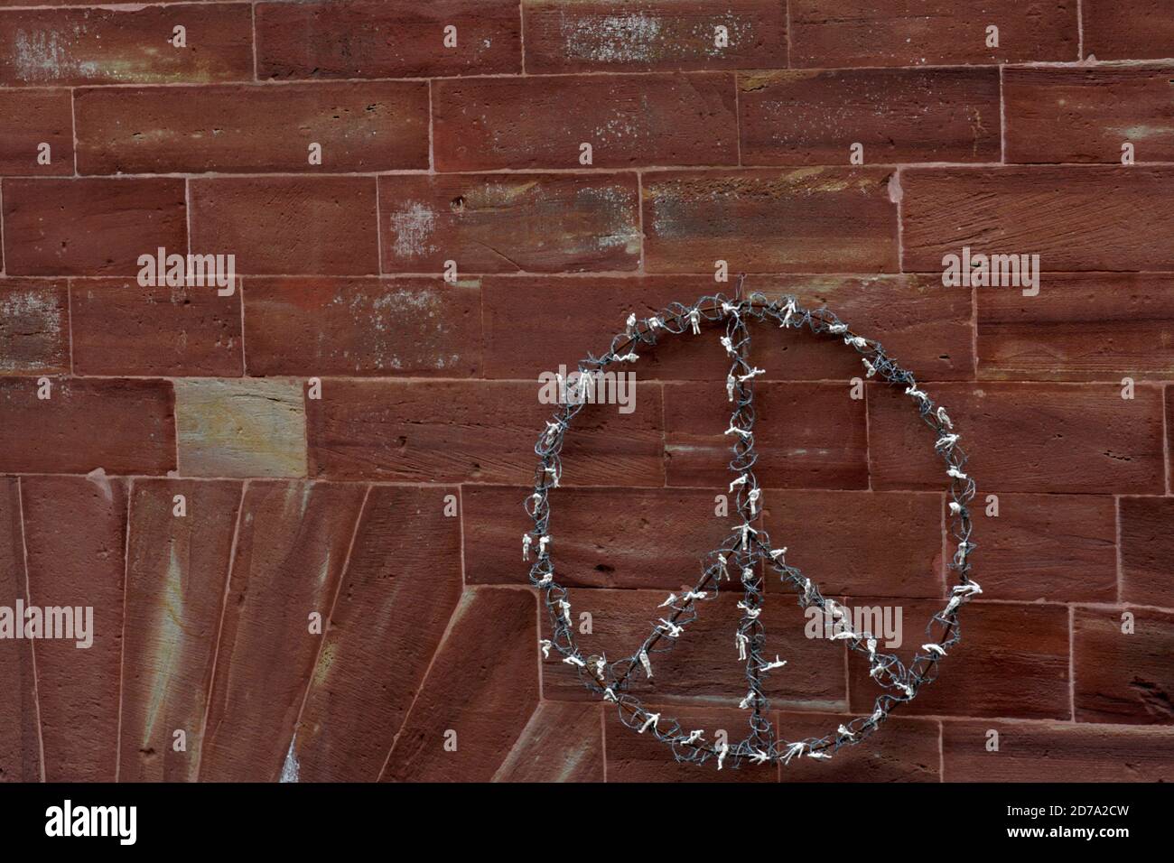 A peace symbol made of barbed wire and small figures in the shape of ...