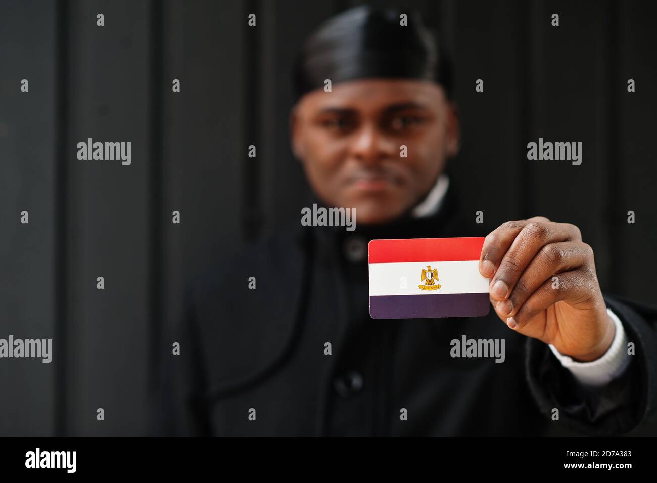 African man wear black durag hold Egypt flag at hand isolated dark ...