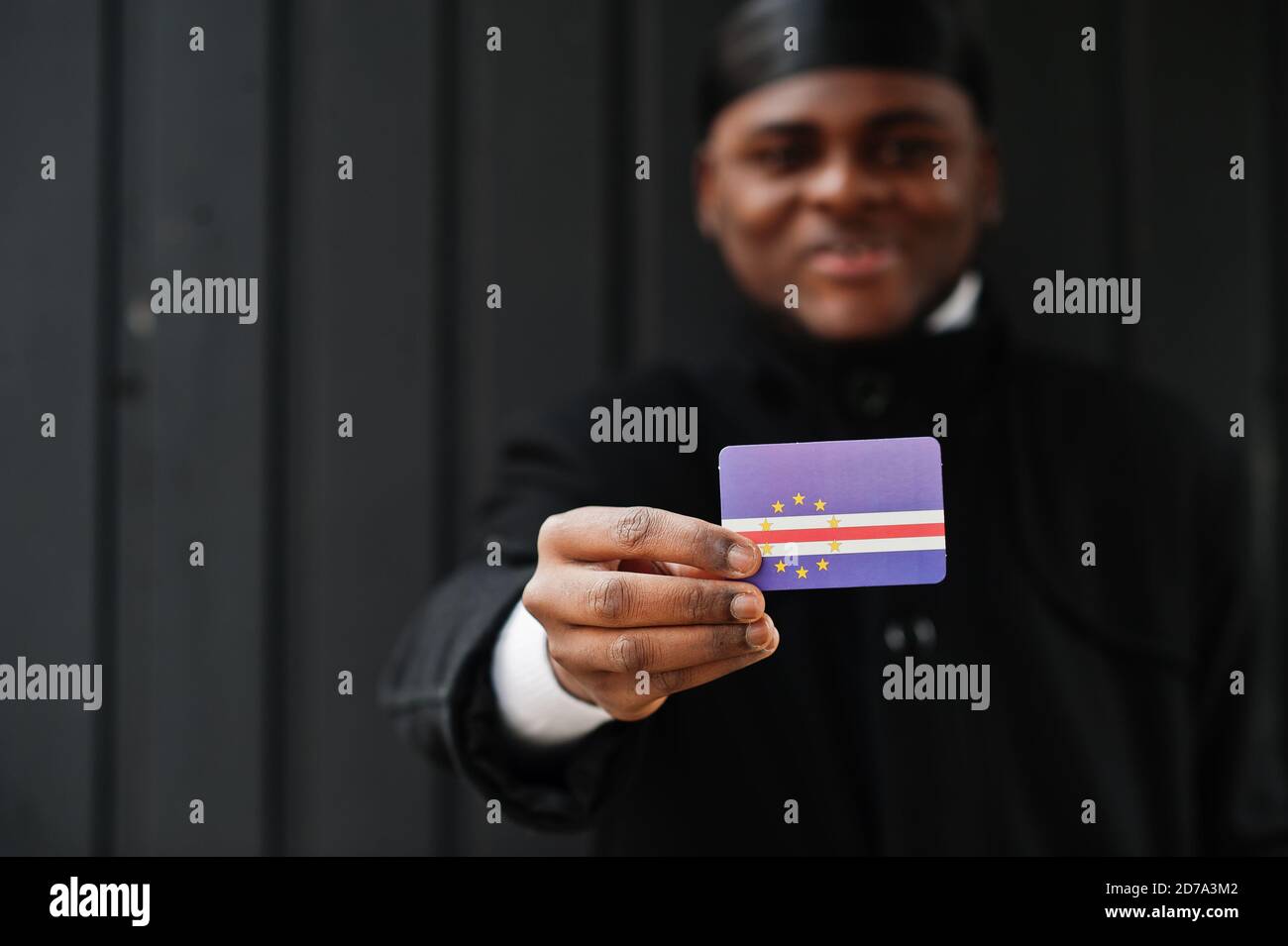 African man wear black durag hold Cape Verde flag at hand isolated dark ...