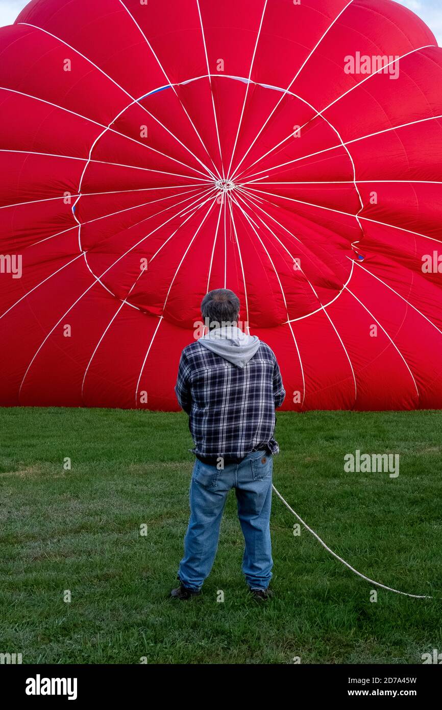 Workman anchors balloon while inflating Stock Photo - Alamy