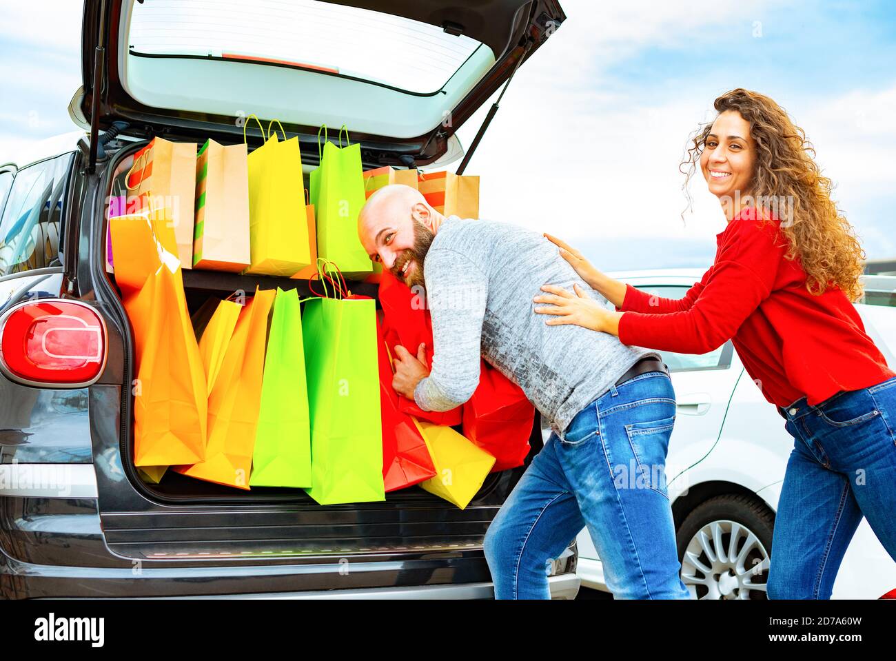 couple of a bearded bolt man and a brunette curly woman making shopping ...
