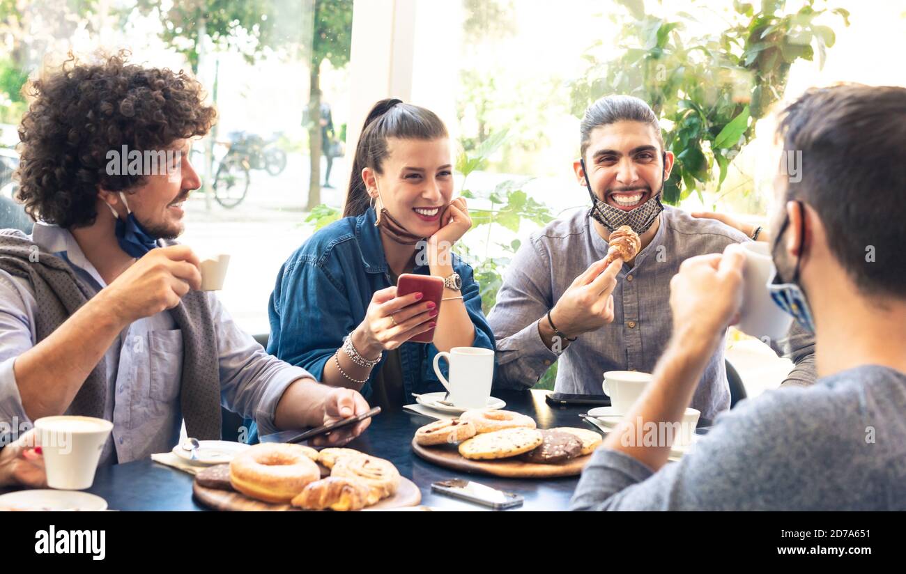 happy group of friends smiling at breakfast into a cafe whilst ...