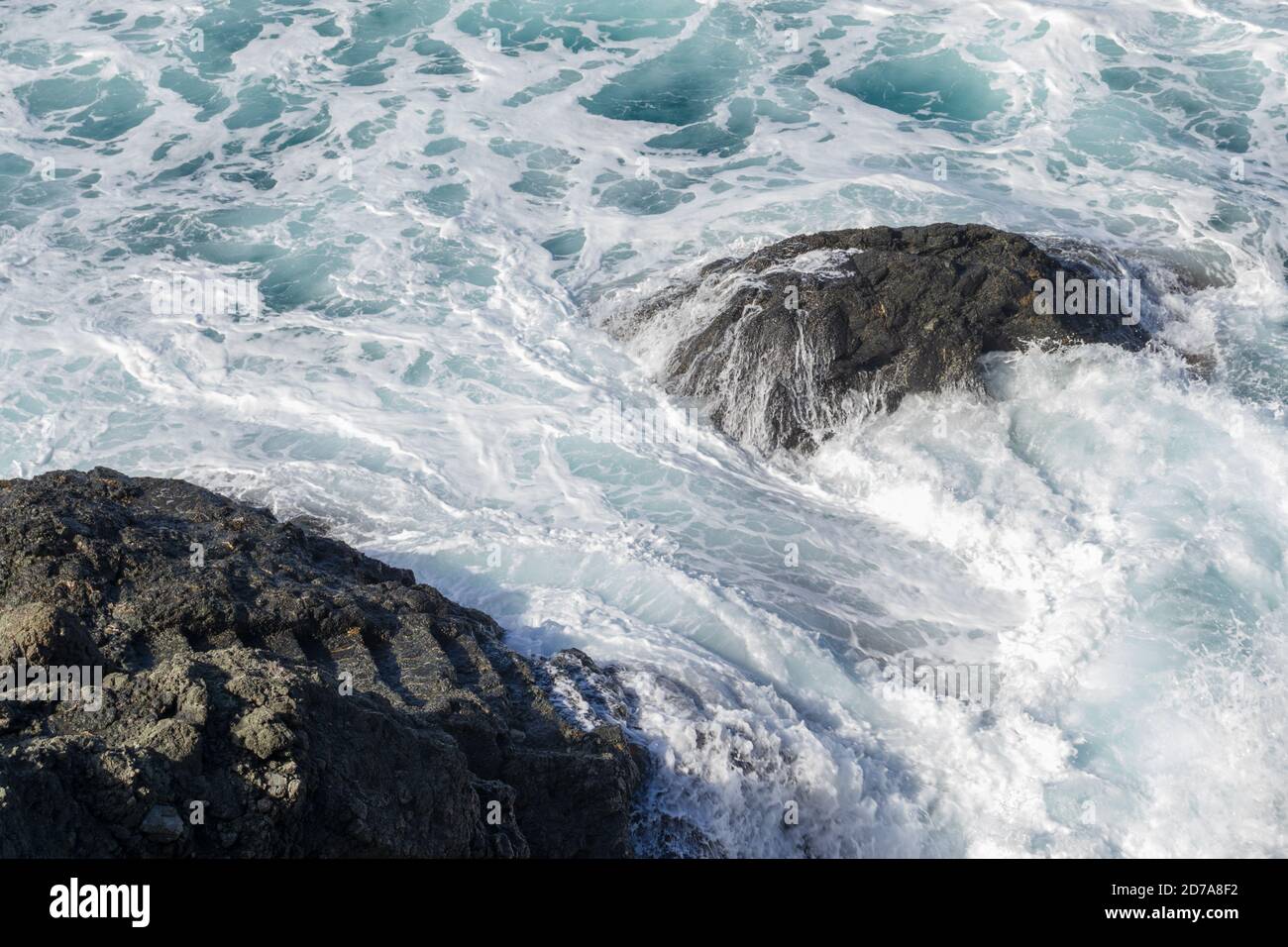 Sea waves with foam on rocks coast Stock Photo - Alamy