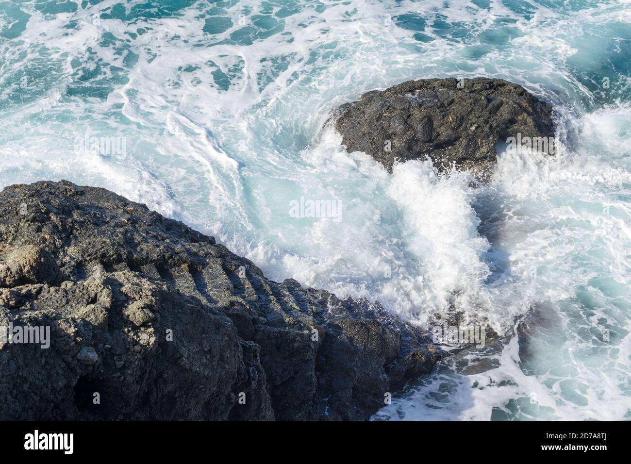 Sea waves with foam on rocks coast Stock Photo - Alamy