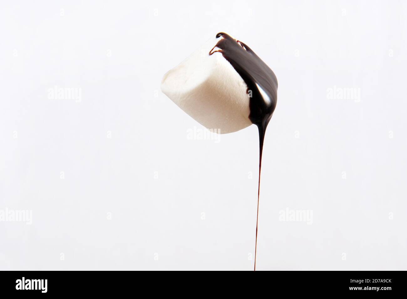 One single marshmallow with chocolate sauce running floating in the air ...