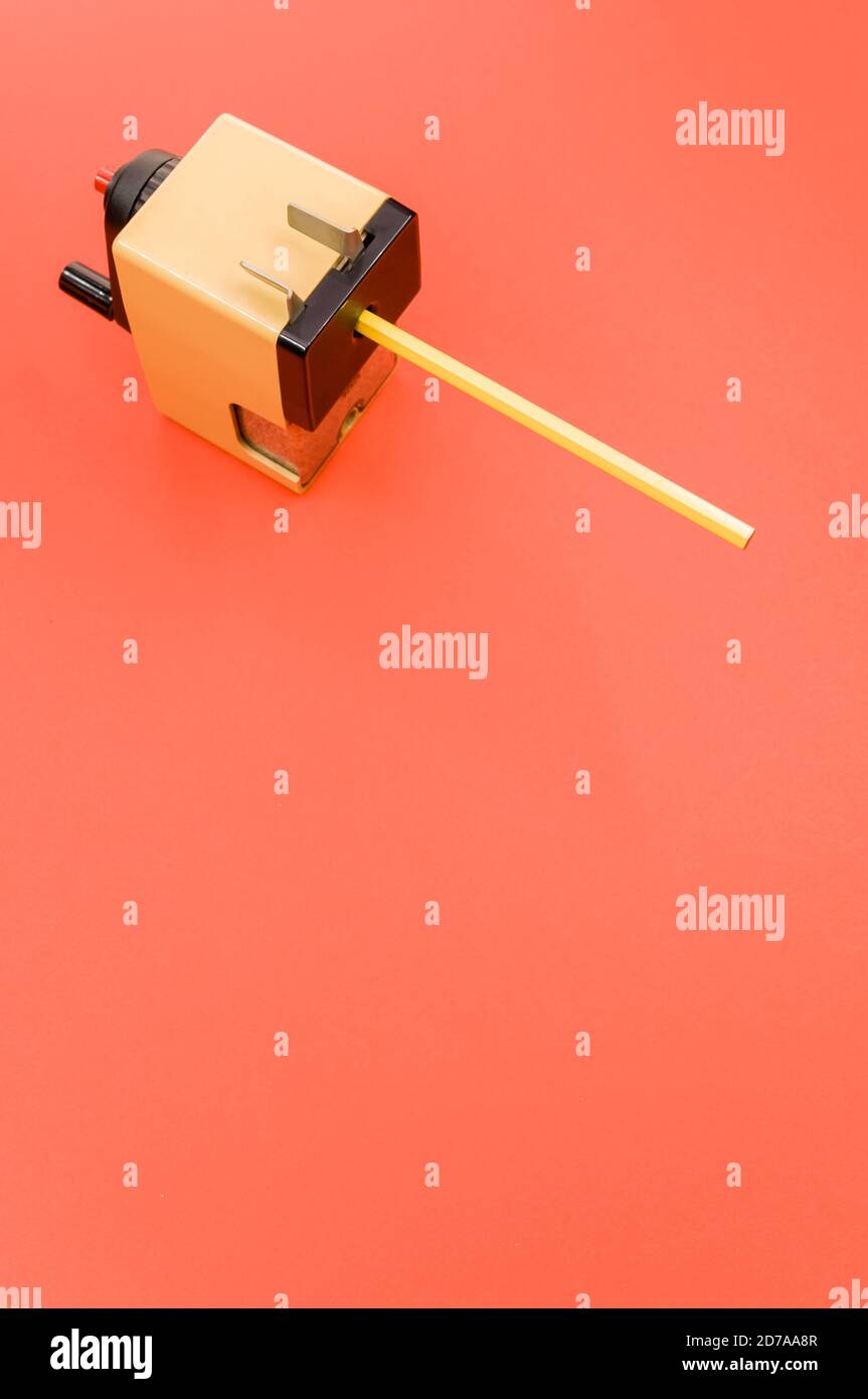 Vertical shot of a mechanical pencil sharpener on a red surface Stock ...