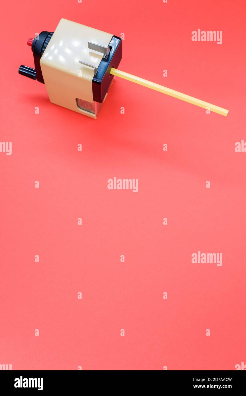 Vertical shot of a mechanical pencil sharpener on a red surface Stock ...
