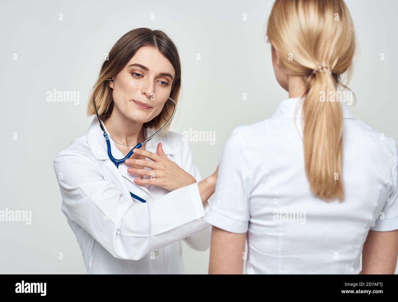 doctor woman in a medical gown with a stethoscope communicates with a ...