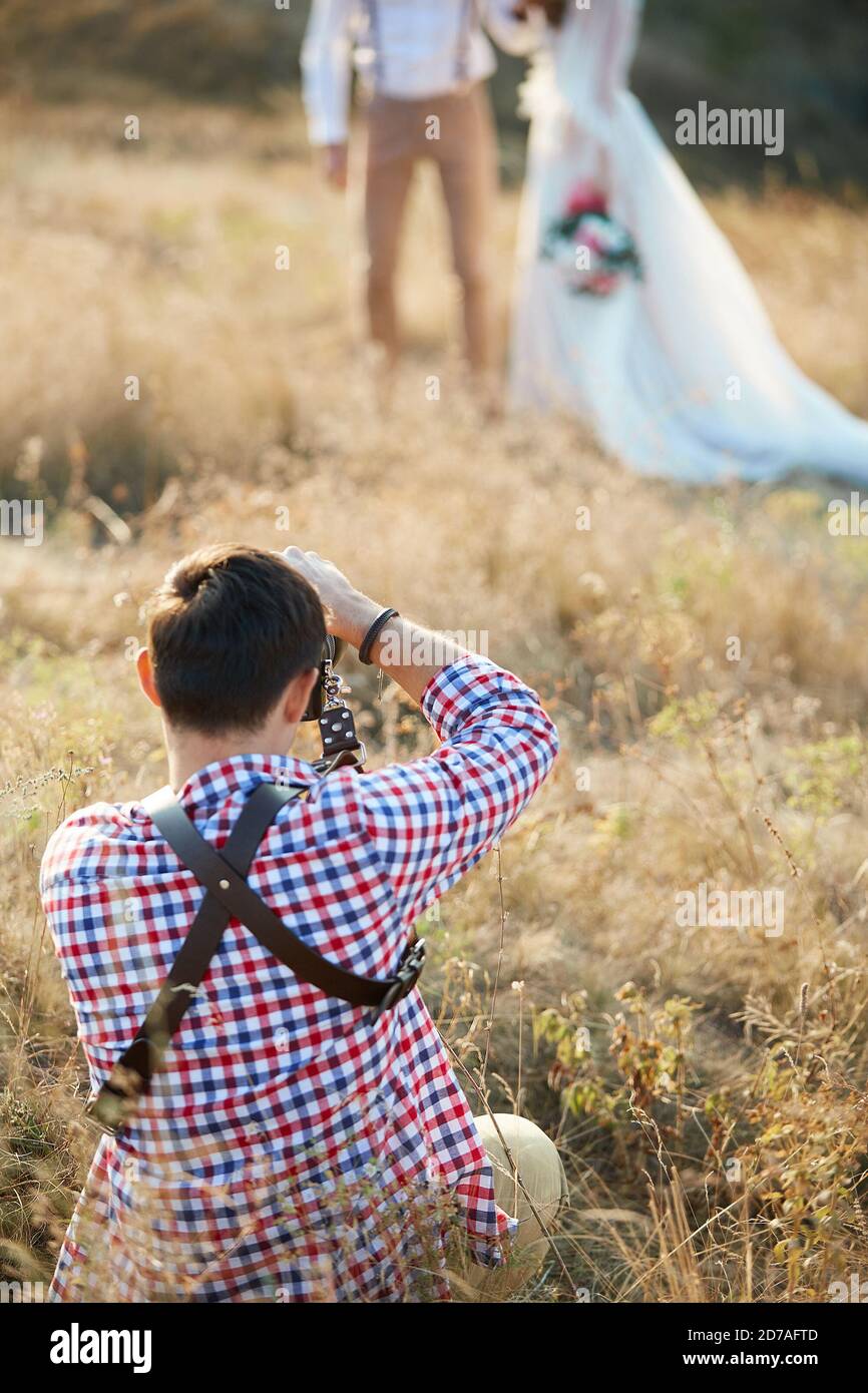 wedding professional photographer takes pictures of the bride and groom ...