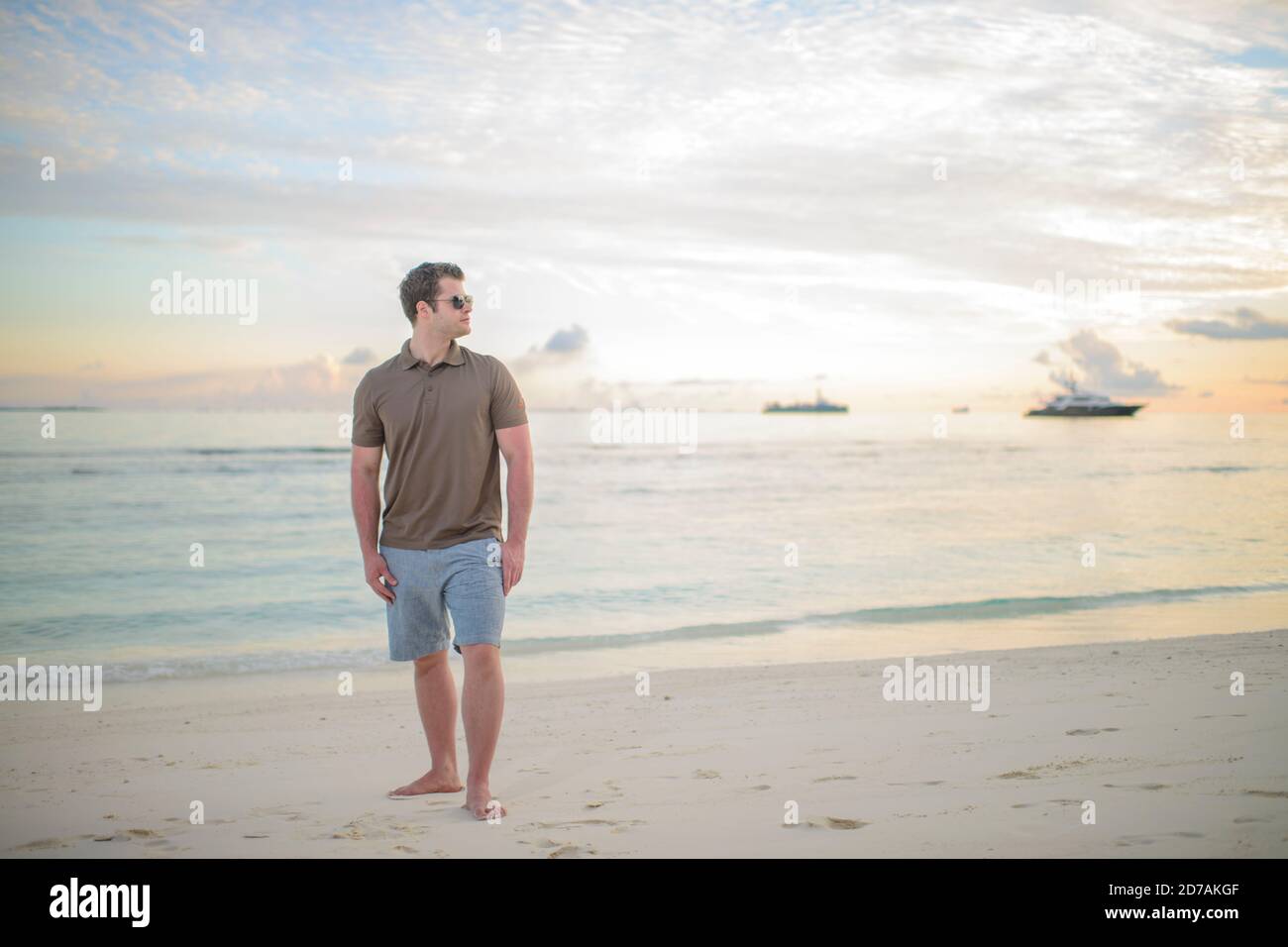 Mann stehend am Strand im Sonnenuntergang auf den Malediven Stock Photo ...