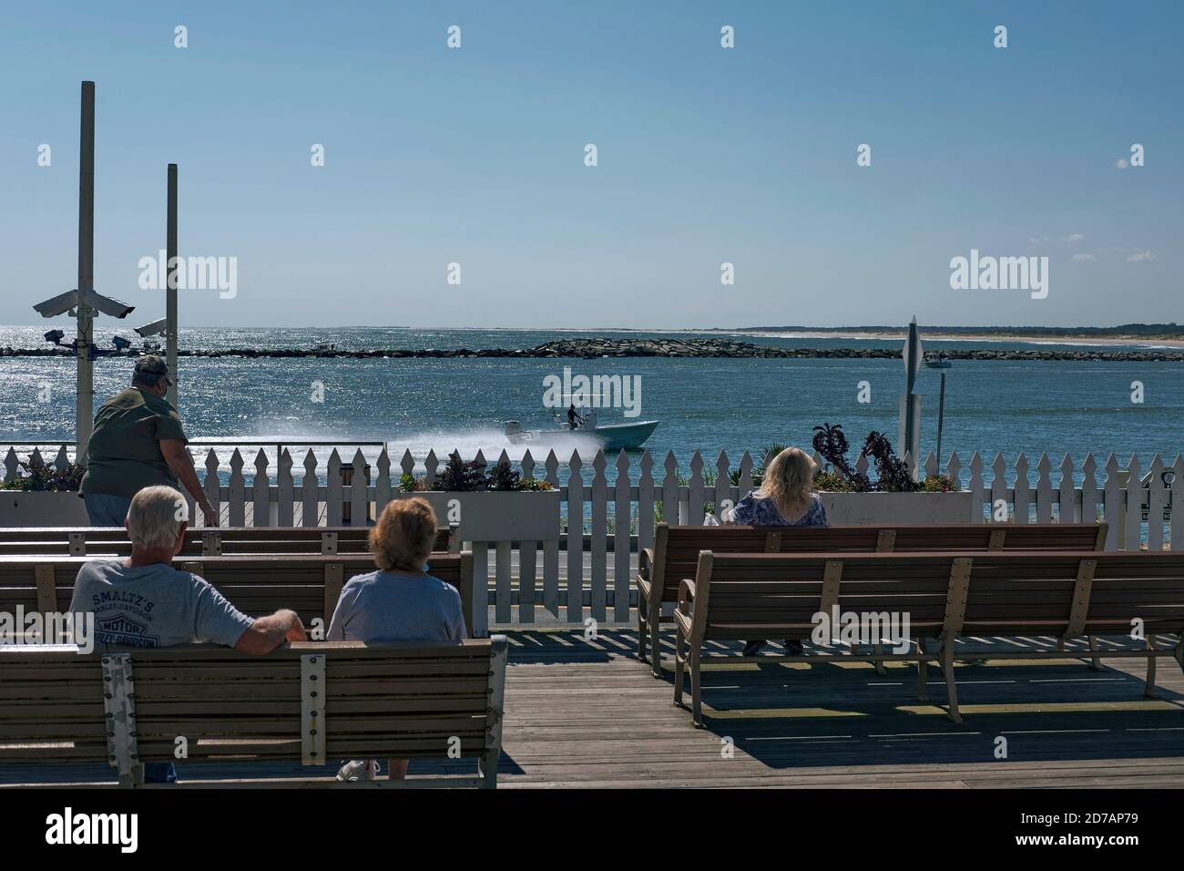 People enjoying a view of the Ocean City, MD Inlet on a sunny day while ...