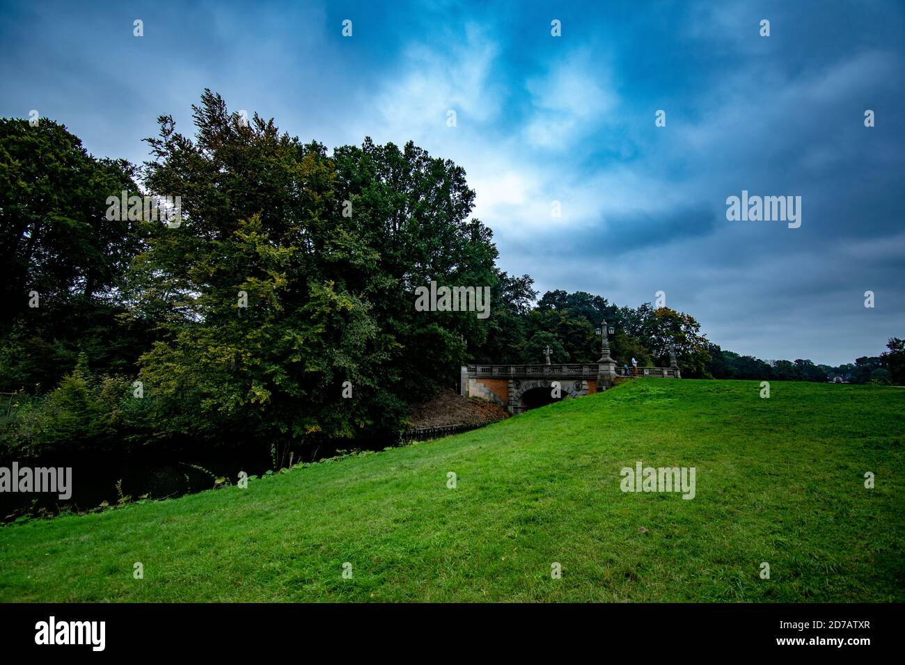 Stone-made arched bridge under a cloudy sky in Burgerpark, Bremen ...