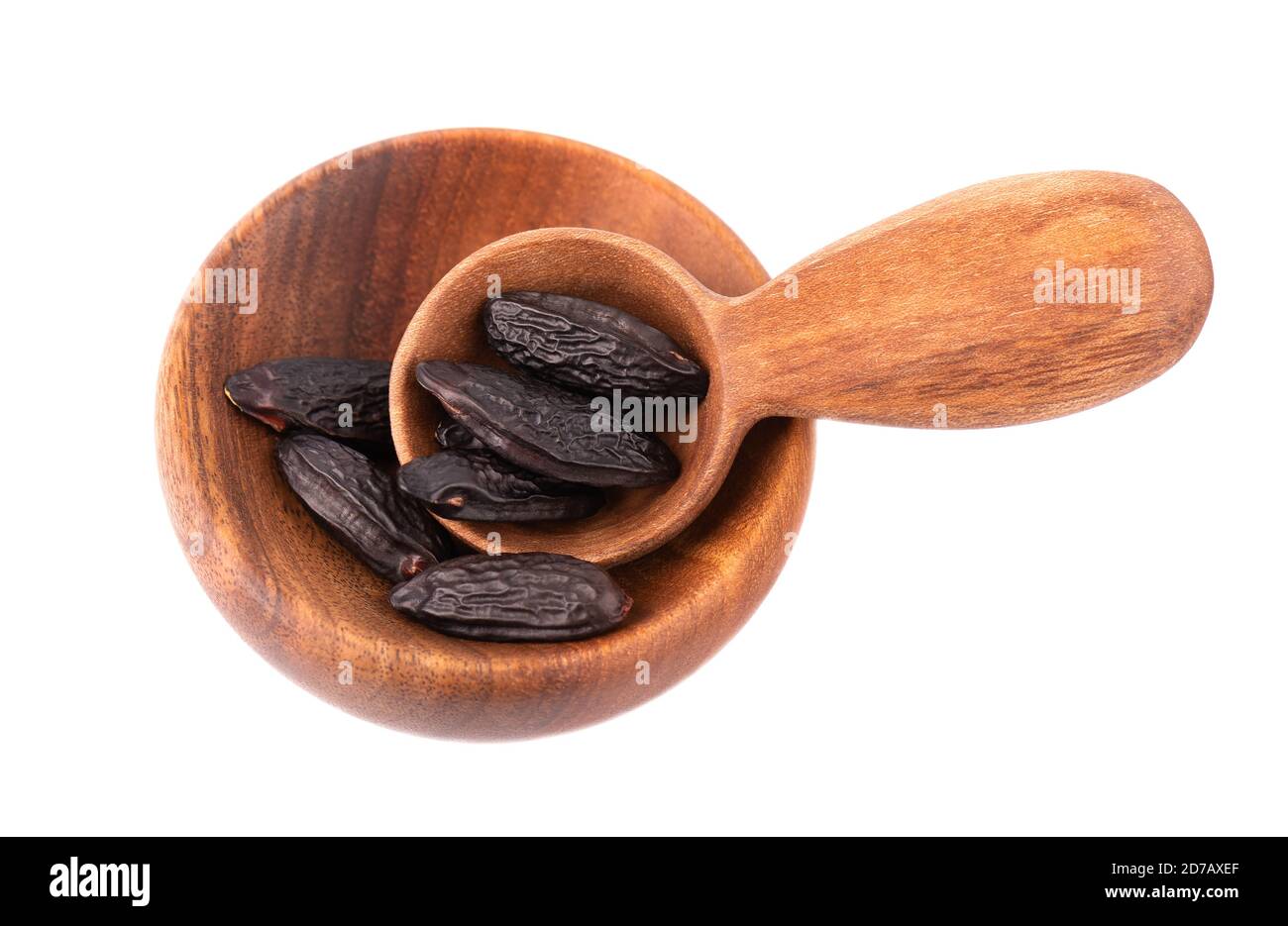 Tonka beans in wooden bowl and spoon, isolated on white background ...