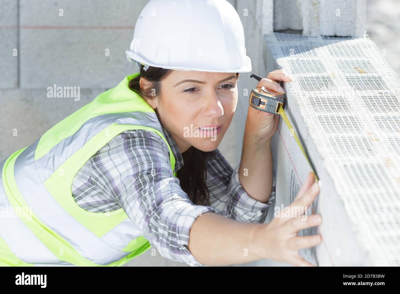 woman builder measuring a block Stock Photo - Alamy