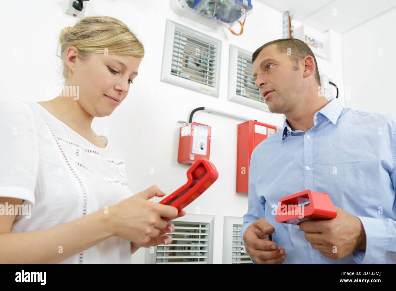 man and woman checking the fire alarm system Stock Photo - Alamy